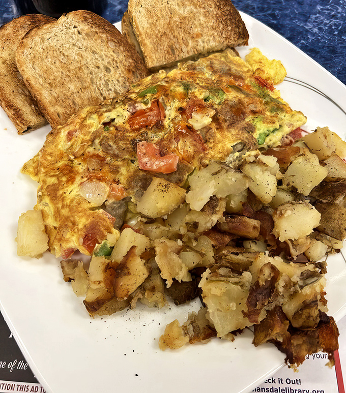 Behold the omelet in its natural habitat&mdash;perfectly folded, generously stuffed, and flanked by home fries that deserve their own zip code.