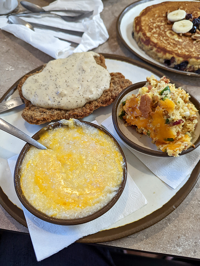 Comfort on a plate: country fried steak smothered in gravy alongside creamy grits and eggs that shine like the Florida sun.