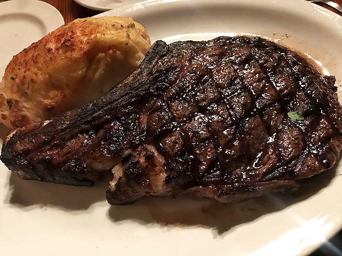 This isn't just a steak; it's a declaration of carnivorous intent, complete with a baked potato sidekick ready for action.