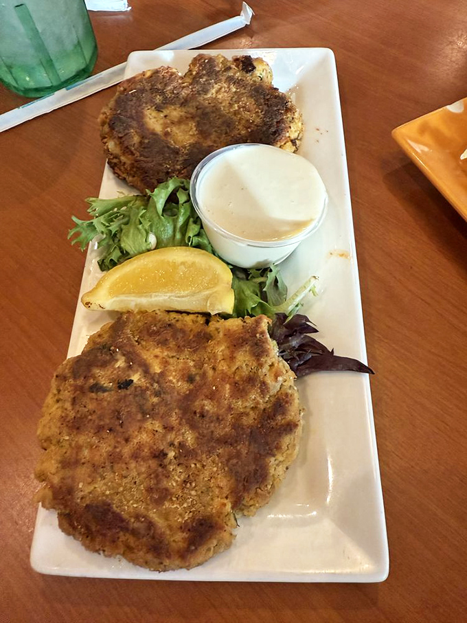 Golden-brown perfection on a plate. These crab cakes are what seafood dreams are made of&mdash;minimal filler, maximum flavor, and that key lime sauce!