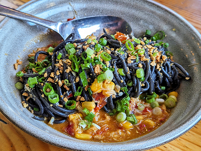 Behold the famous crab fat noodles, where golden strands swim in oceanic richness that defies description.