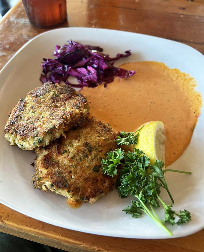 These aren't just crab cakes; they're golden discs of happiness with a sauce so good you'll contemplate drinking it straight.