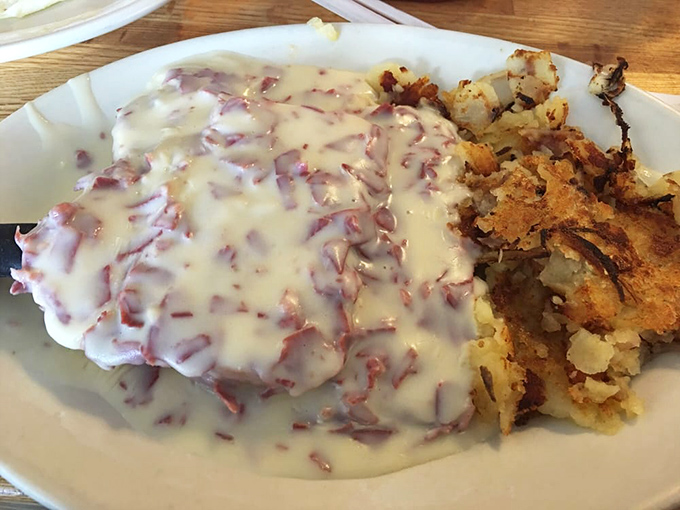 The legendary cream chipped beef in all its glory! Tender dried beef swimming in velvety sauce alongside golden home fries&mdash;comfort food that hugs your soul.