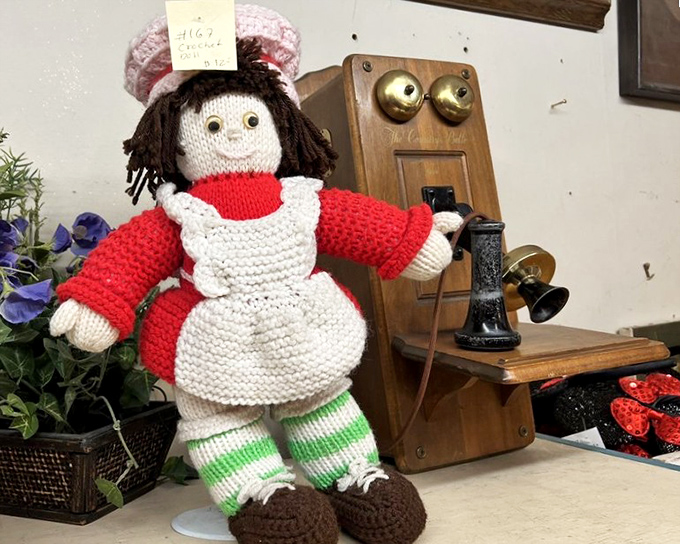 Handcrafted nostalgia meets vintage technology. This knitted doll and antique telephone pairing feels like a time-traveler's unlikely friendship captured in still life.