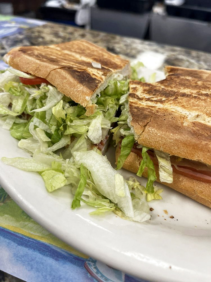 Behold the legendary Cuban sandwich: perfectly pressed golden bread cradling layers of pork, ham, and melted Swiss cheese perfection.