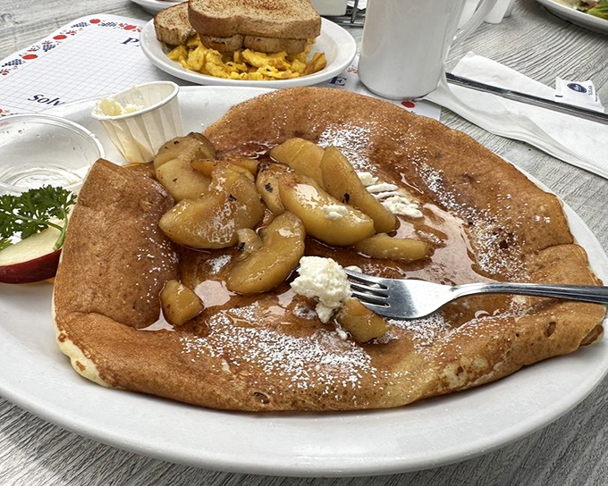 This isn't just a pancake, it's a Danish revelation &ndash; thin, golden, and topped with caramelized apples that would make even the most stoic Viking weep with joy.