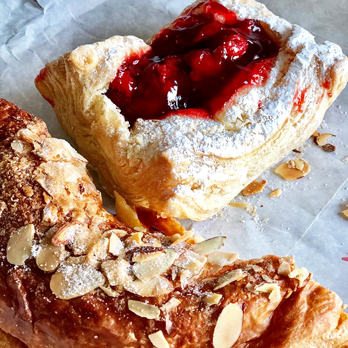 These Danish pastries aren't just breakfast, they're an event – layers of butter-laden dough cradling fruit filling that makes you question all other breakfast choices.
