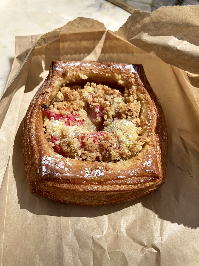 This fruit danish isn't just breakfast&mdash;it's edible architecture with its perfectly laminated layers and ruby-red filling peeking through a golden crumble top.