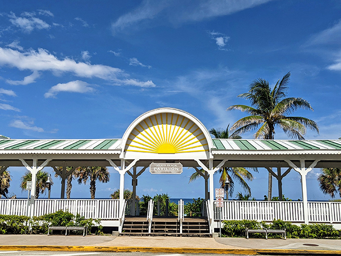 The beach pavilion stands like a cheerful sunburst against the sky, a gateway between civilization and the endless blue horizon beyond.