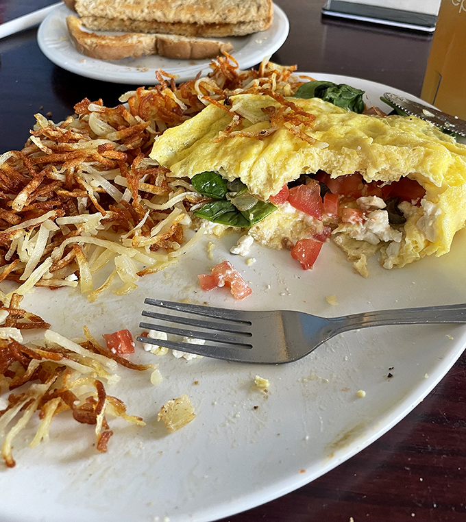 This omelet has more layers than your favorite novel&mdash;fluffy eggs, vibrant veggies, and those hashbrowns! Crispy on the outside, tender within.