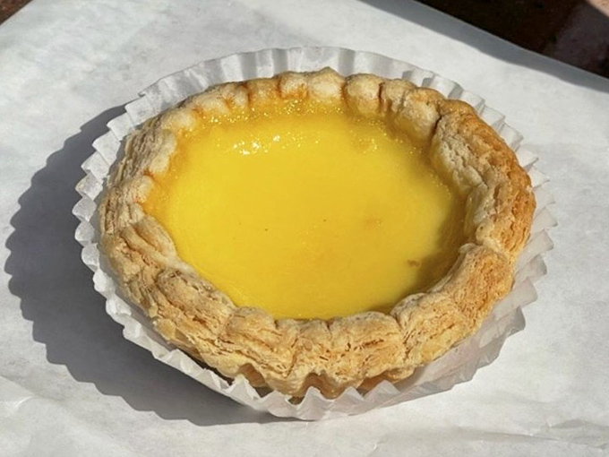 Behold the star attraction: a perfectly executed egg tart with that signature wobble and golden hue that whispers, "Yes, I'm worth the drive."