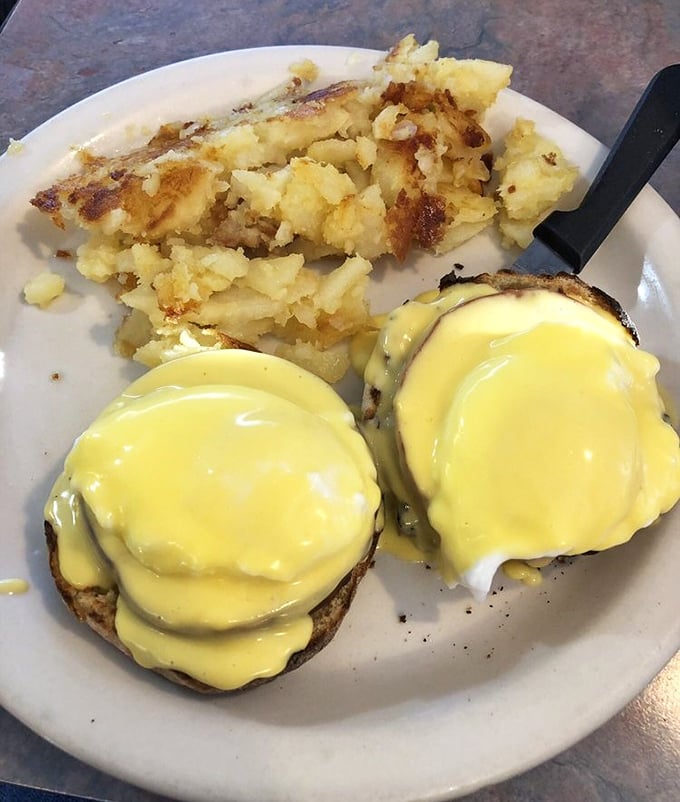 Behold, the star attraction! Two golden-domed poached eggs draped in sunshine-yellow hollandaise that would make Julia Child weep with joy.