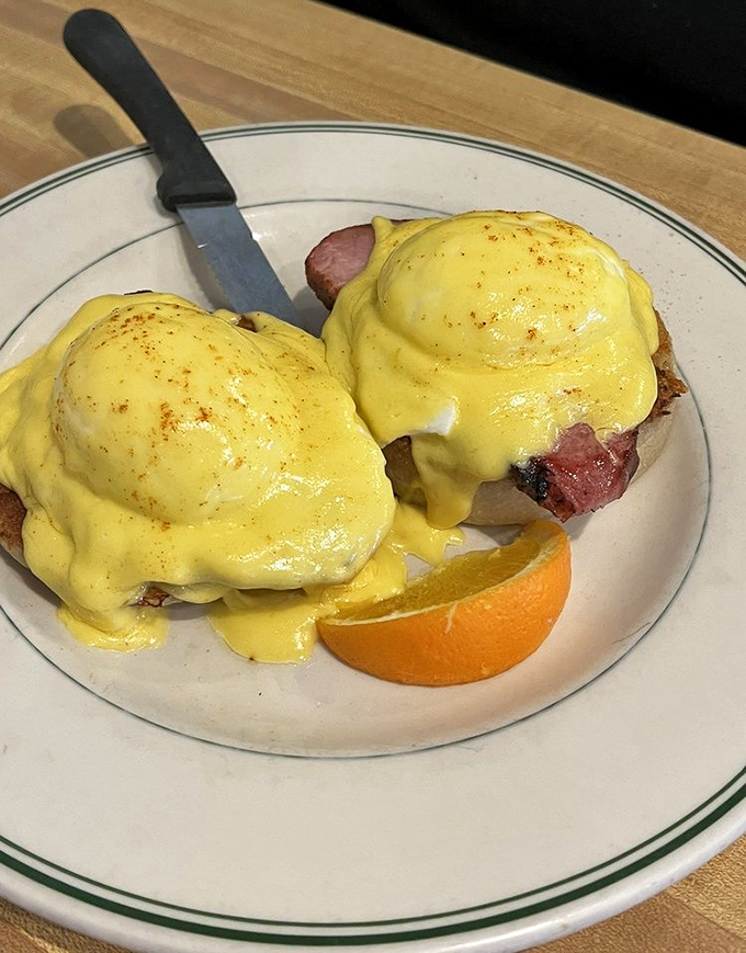 Eggs Benedict done right—perfectly poached eggs nestled on ham, draped in hollandaise that's sunshine on a plate.