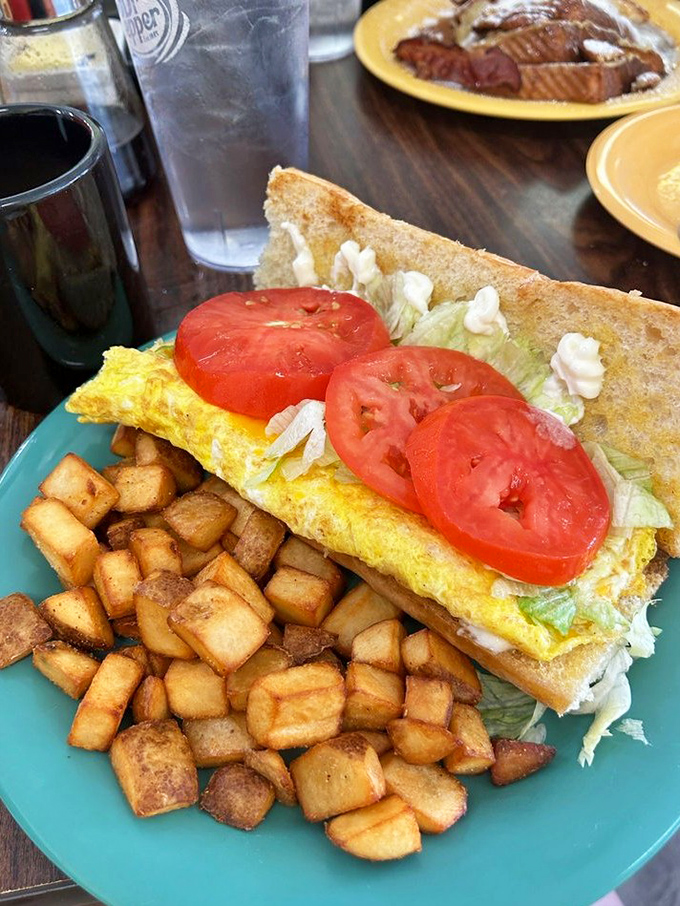 This breakfast sandwich isn't trying to win a beauty pageant – it's too busy perfecting the holy trinity of eggs, toast, and those gloriously golden home fries.