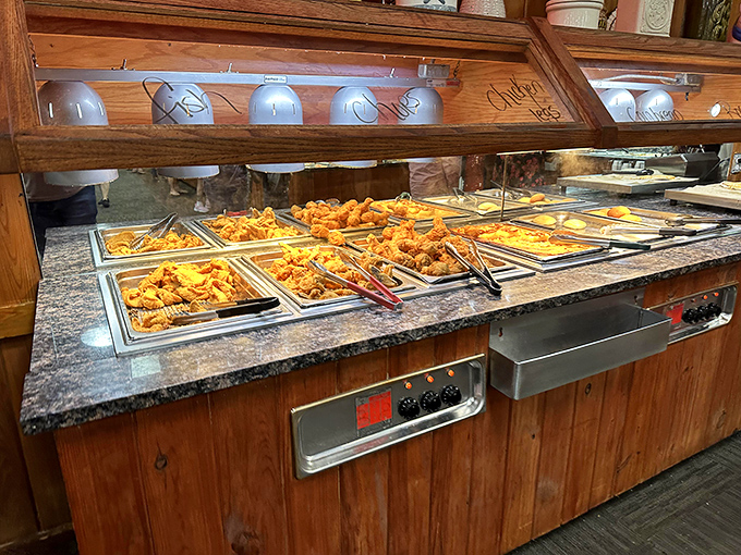 Behold the golden landscape of fried delights! This steam table vista promises a journey through Southern cuisine that no GPS could navigate.