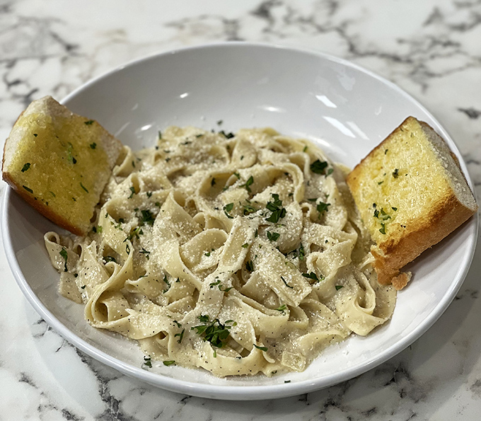 Fettuccine Alfredo so creamy it should come with a warning label. Those garlic bread bookends aren't just accessories &ndash; they're sauce-sopping necessities.