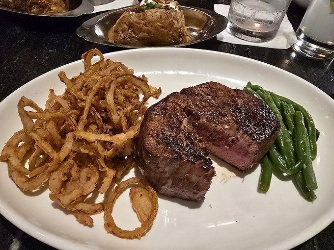 Behold the star of the show&mdash;a perfectly seared filet mignon flanked by crispy onion strings and vibrant green beans. Meat poetry on a plate.