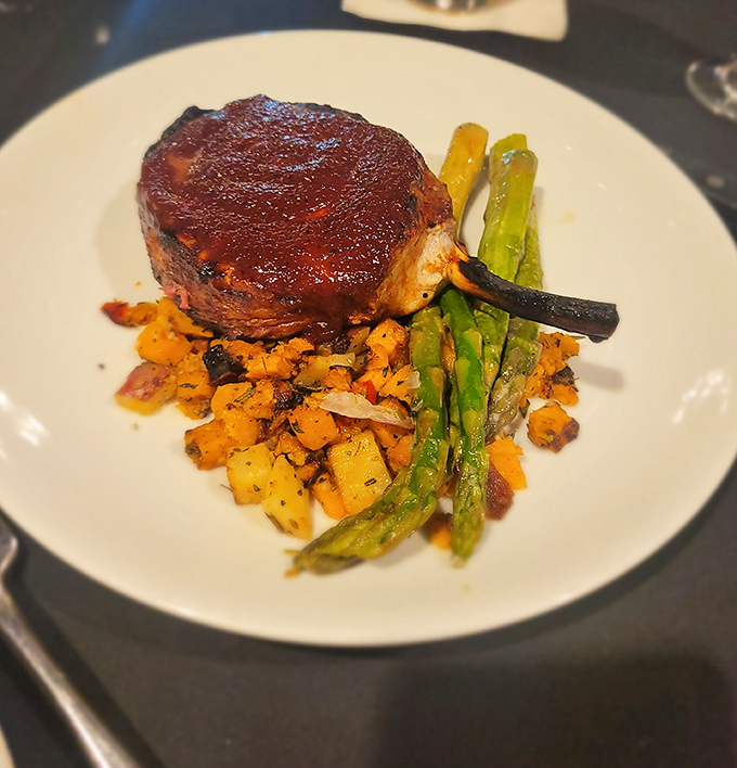 Behold the star of the show: a filet mignon so perfectly seared it makes other steaks feel like they need therapy.