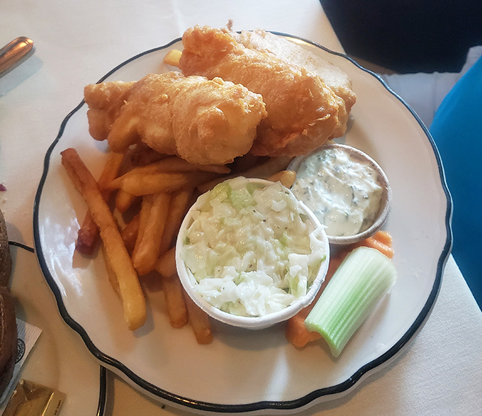 Golden-battered fish that shatters like delicate glass, with fries and coleslaw standing by as loyal sidekicks in this superhero meal of comfort.