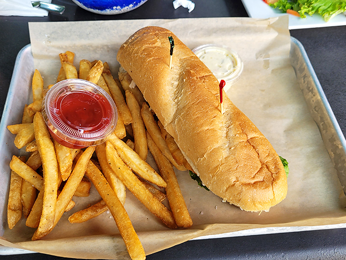 This isn't just a sandwich; it's edible architecture. Golden-battered fish on a pillow-soft roll with fries that could start their own fan club.
