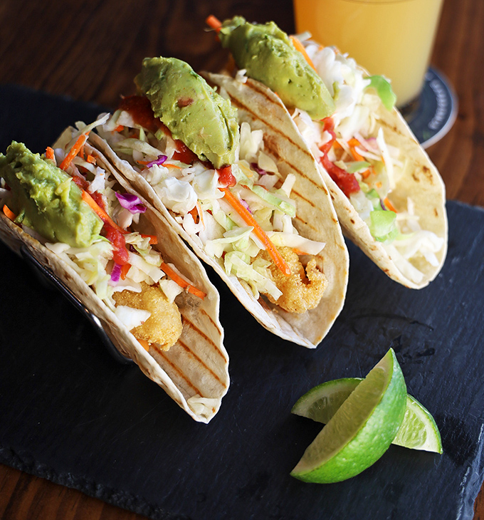 These fish tacos aren't just served – they're presented with pride. Crispy battered fish, fresh slaw, and avocado create the holy trinity of taco perfection.