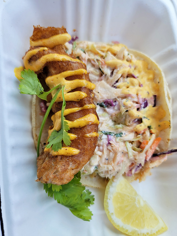 This fish taco isn't just food&mdash;it's edible proof that barbecue joints can master seafood too, especially with that perfect drizzle of sauce.