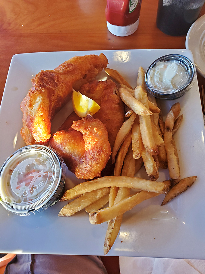 Golden, crispy beer-battered grouper that breaks apart with the gentlest fork pressure, paired with fries that deserve equal billing. This is Florida on a plate.