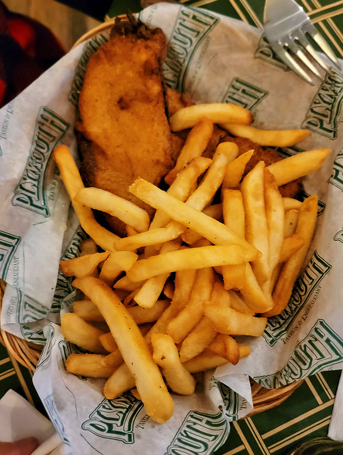 Golden-battered haddock resting on a bed of perfectly crisp fries &ndash; this isn't just fish and chips, it's edible poetry wrapped in Plymouth's signature paper.
