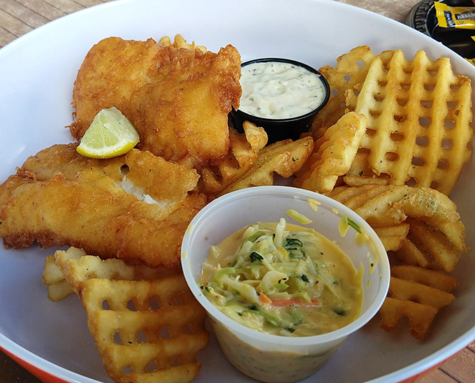 Golden-battered fish that shatters with each bite, paired with waffle fries that could make a potato proud. That tartar sauce deserves its own fan club.