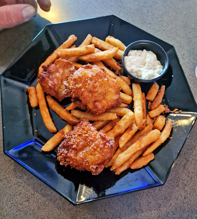 Golden-battered fish that shatters with each bite, surrounded by a fortress of perfectly crisp fries. The tartar sauce deserves its own fan club.