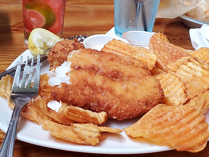 Golden-battered fish surrounded by crispy chips—this isn't just fried fish, it's edible sunshine that shatters with a satisfying crunch at first bite.