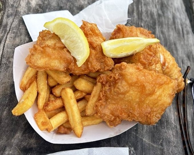 Golden perfection on a paper plate. That fish looks like it's wearing a tuxedo made of crispy batter to its own delicious farewell party.