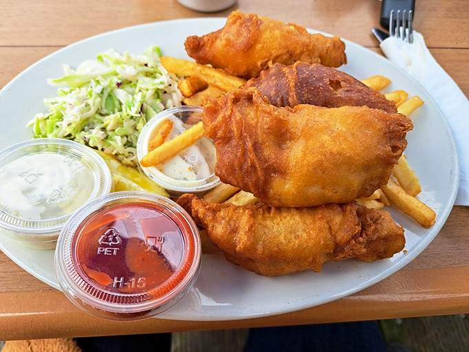 Golden-battered fish and chips that shatter with each bite, served with the kind of fries that disappear mysteriously fast.