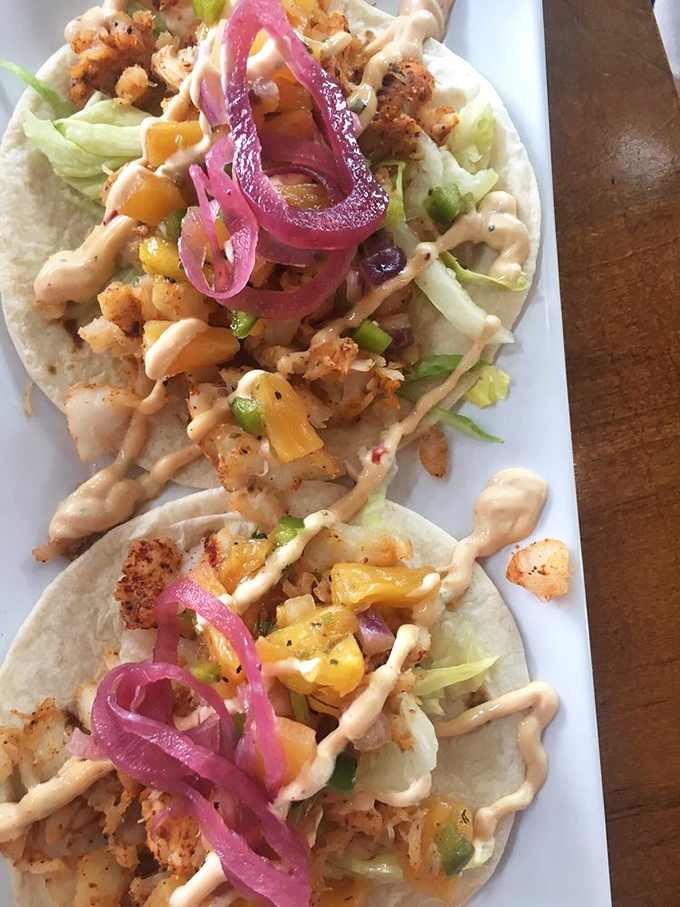 These fish tacos arrive dressed to impress, with pickled onions adding that perfect tangy plot twist.