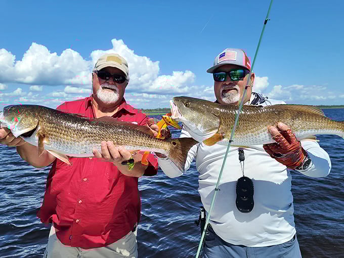 Two anglers display their redfish prizes with the kind of grins usually reserved for lottery winners.