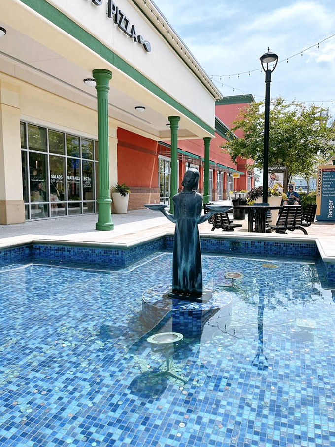 A serene blue fountain provides the perfect respite when your shopping bags become too heavy. The statue silently judges your impulse purchases.