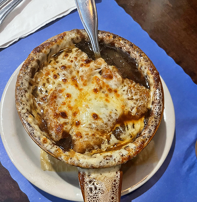Behold the crown jewel: French onion soup with a cheese cap so perfectly browned it deserves its own trophy in the Comfort Food Hall of Fame.
