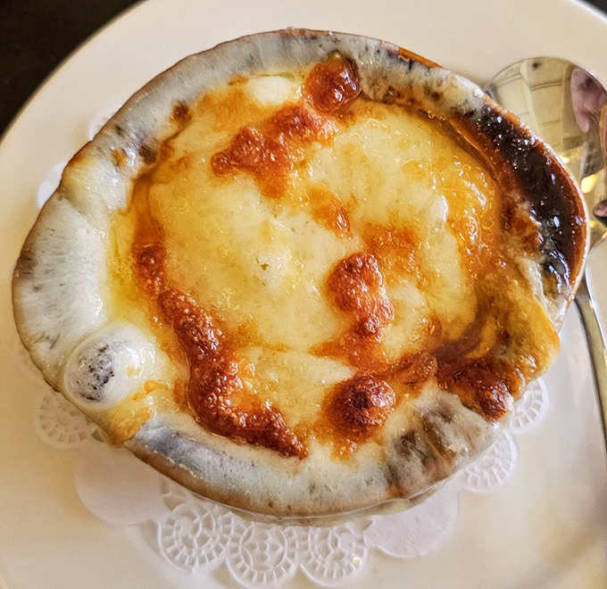 Behold the crown jewel: French onion soup with a cheese cap so perfectly bronzed it deserves its own spot in the Louvre.