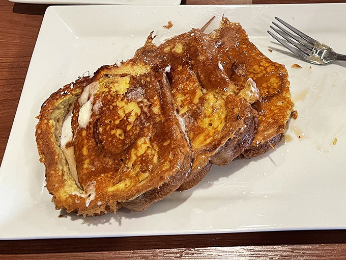 Golden-brown French toast that makes you understand why breakfast deserves its own time zone. Three perfect slices of custard-soaked heaven that render conversation unnecessary.
