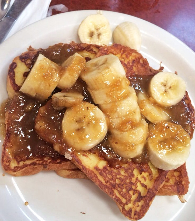French toast that makes you question all other breakfast decisions. Those bananas aren't just toppings; they're co-conspirators in deliciousness.