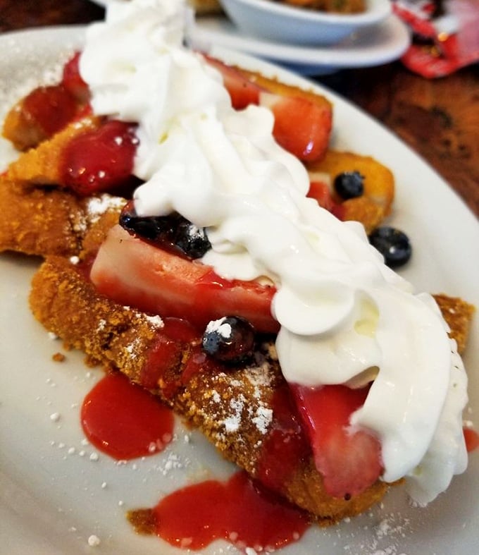 This isn't just French toast &ndash; it's a berry-crowned masterpiece with enough whipped cream to make your cardiologist wince and your taste buds applaud.