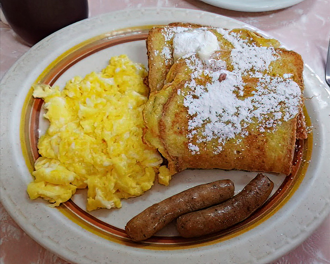 The French Toast Combo in all its glory &ndash; golden-brown perfection dusted with powdered sugar, alongside eggs and sausage that make waking up worthwhile.