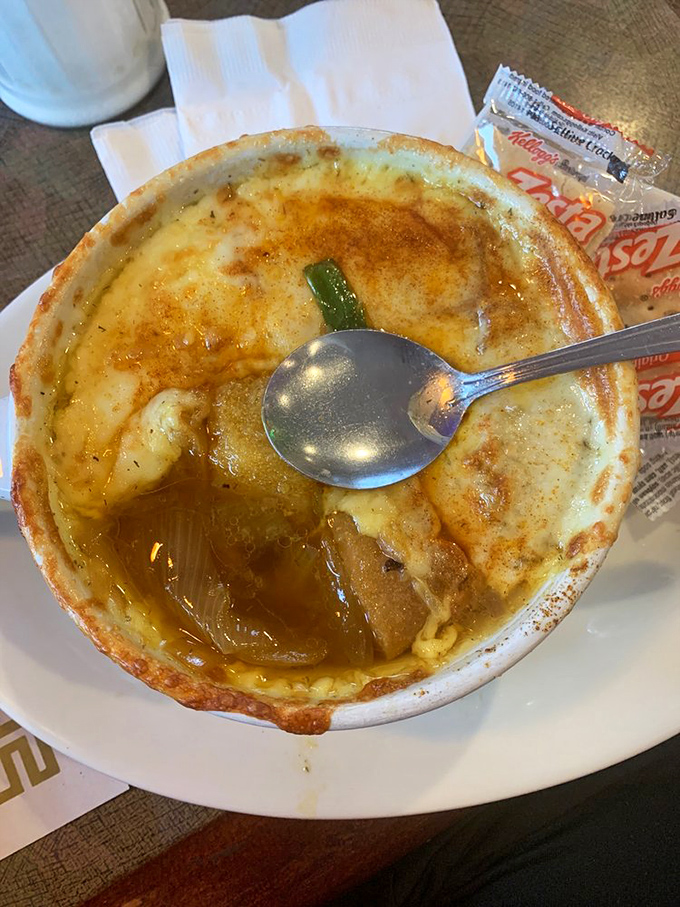 The legendary French onion soup arrives with a cheese canopy that stretches like the finale of a culinary magic show. 