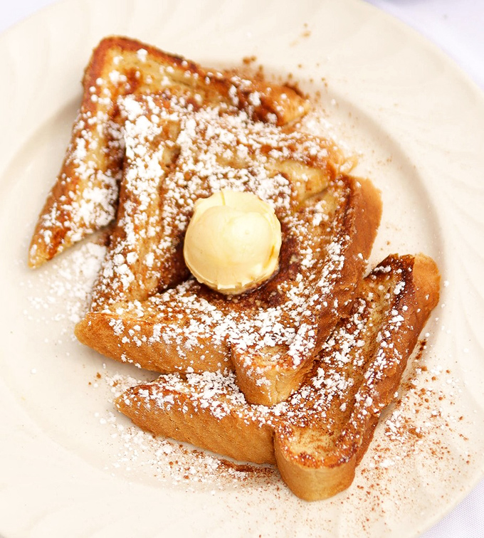 Golden-brown French toast dusted with powdered sugar and topped with a perfect scoop of butter. Breakfast nirvana that makes you question why you'd ever order anything else.