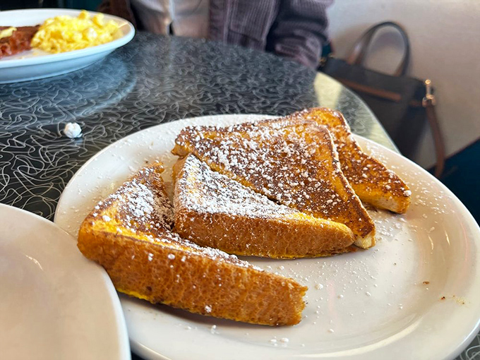 Golden French toast dusted with powdered sugar—proof that bread can achieve greatness with just a quick egg bath.