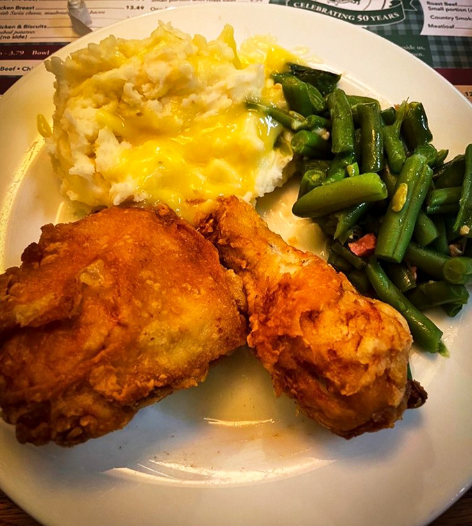 Golden-brown fried chicken that shatters at first bite, alongside cheese-topped mashed potatoes and green beans that haven't forgotten their Southern roots.