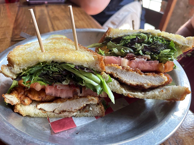 This isn't just a sandwich; it's architecture. Layers of crispy chicken, fresh veggies, and creamy avocado relish create the skyscraper of satisfaction.