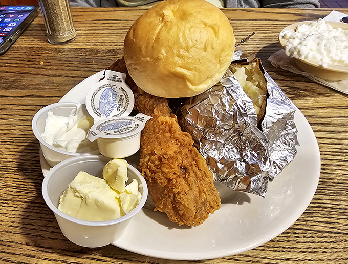Golden-brown fried chicken that makes a satisfying crunch heard 'round the table, paired with a foil-wrapped potato that's practically bursting with buttery potential.
