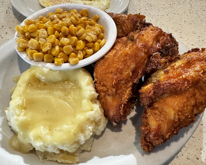 The holy trinity of comfort: golden fried chicken, cloud-like mashed potatoes with gravy, and buttery corn. A plate that hugs you from the inside.