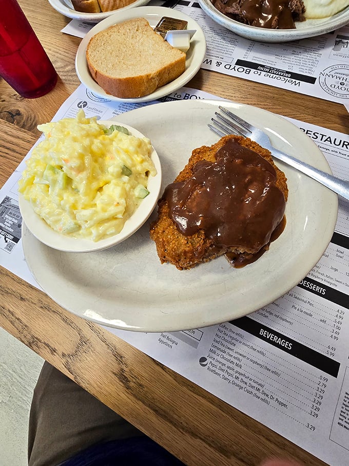 Country fried steak smothered in gravy alongside creamy macaroni salad&mdash;a plate that whispers, "Your diet starts tomorrow, and we both know it."